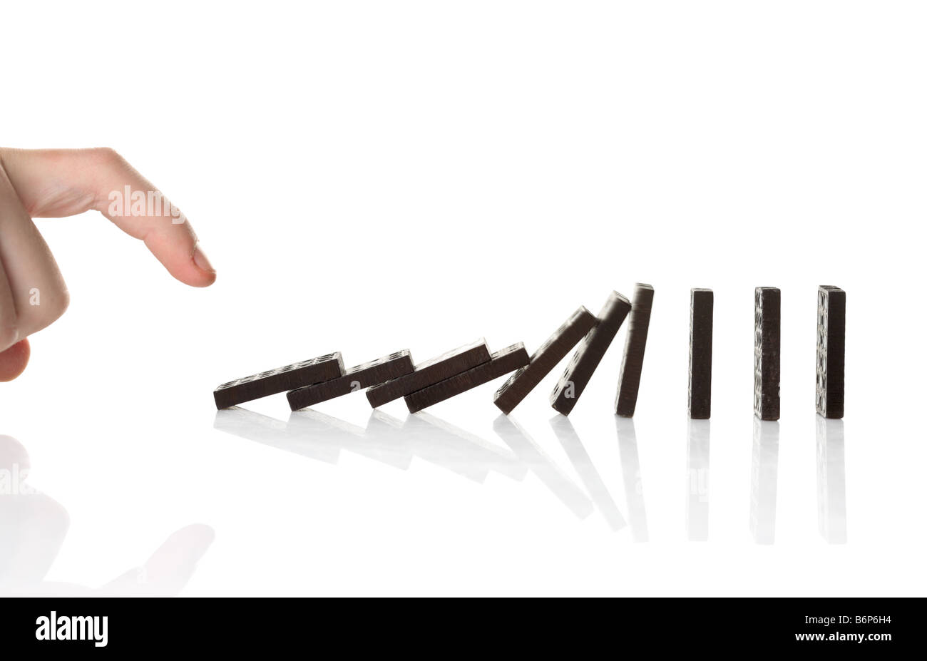 Pushing dominoes causing chain reaction Stock Photo - Alamy