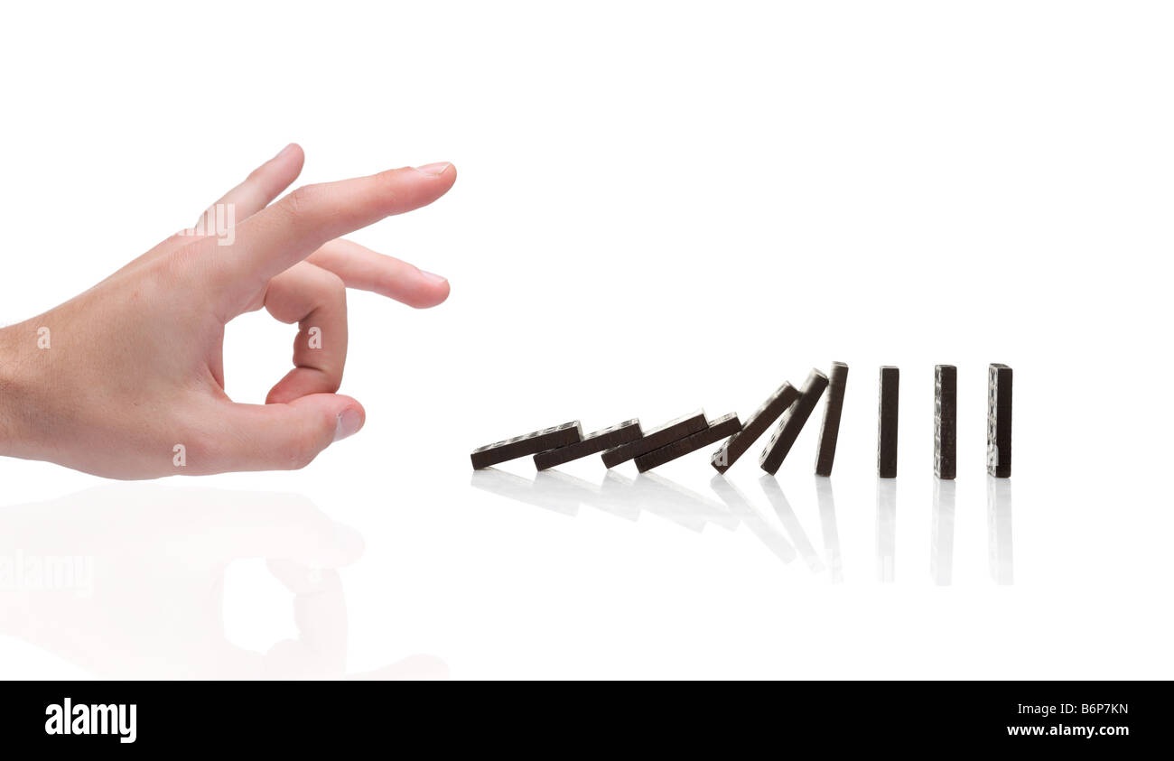 Pushing dominoes causing chain reaction Stock Photo - Alamy