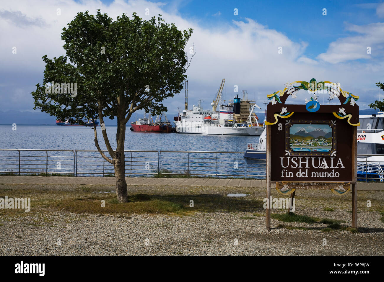 Sign announcing the end of the world in Ushuaia town and harbour in ...