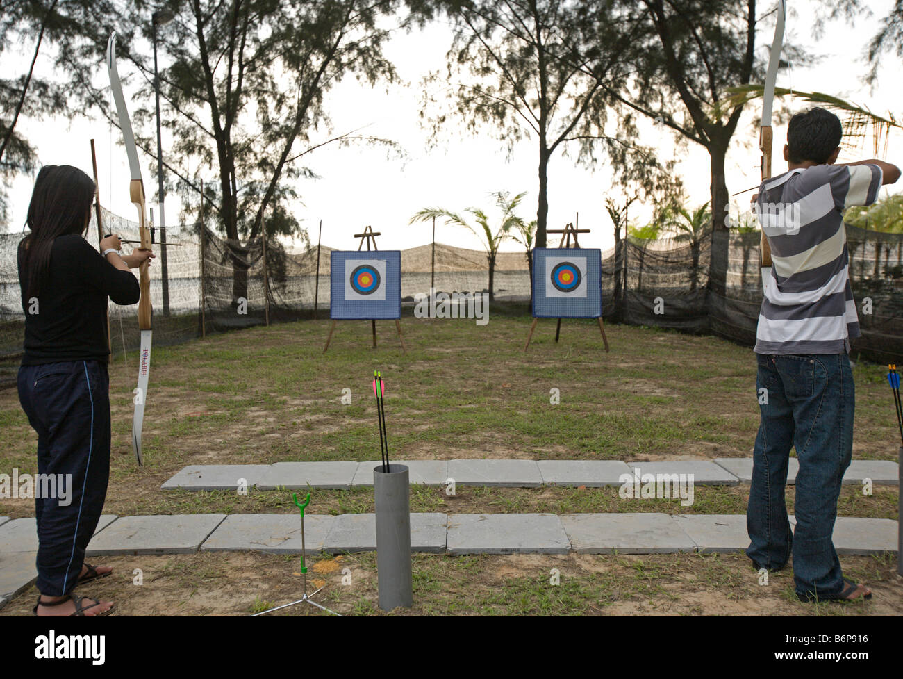 2 persons practising archery in Bagan Lalang, Malaysia Stock Photo - Alamy
