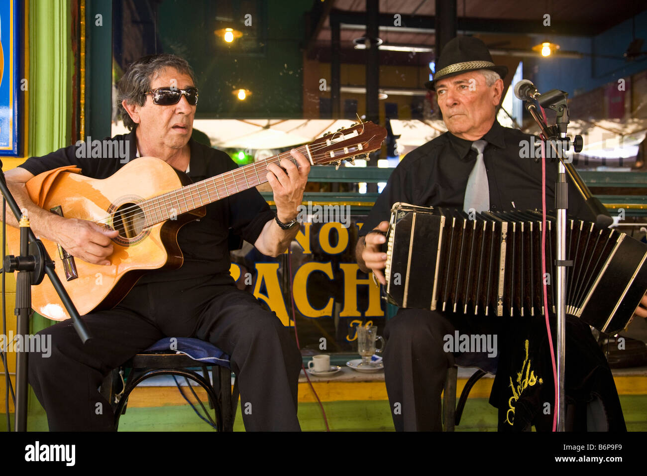 Musicians play guitar and accordion in street cafe in La Boca Buenos ...