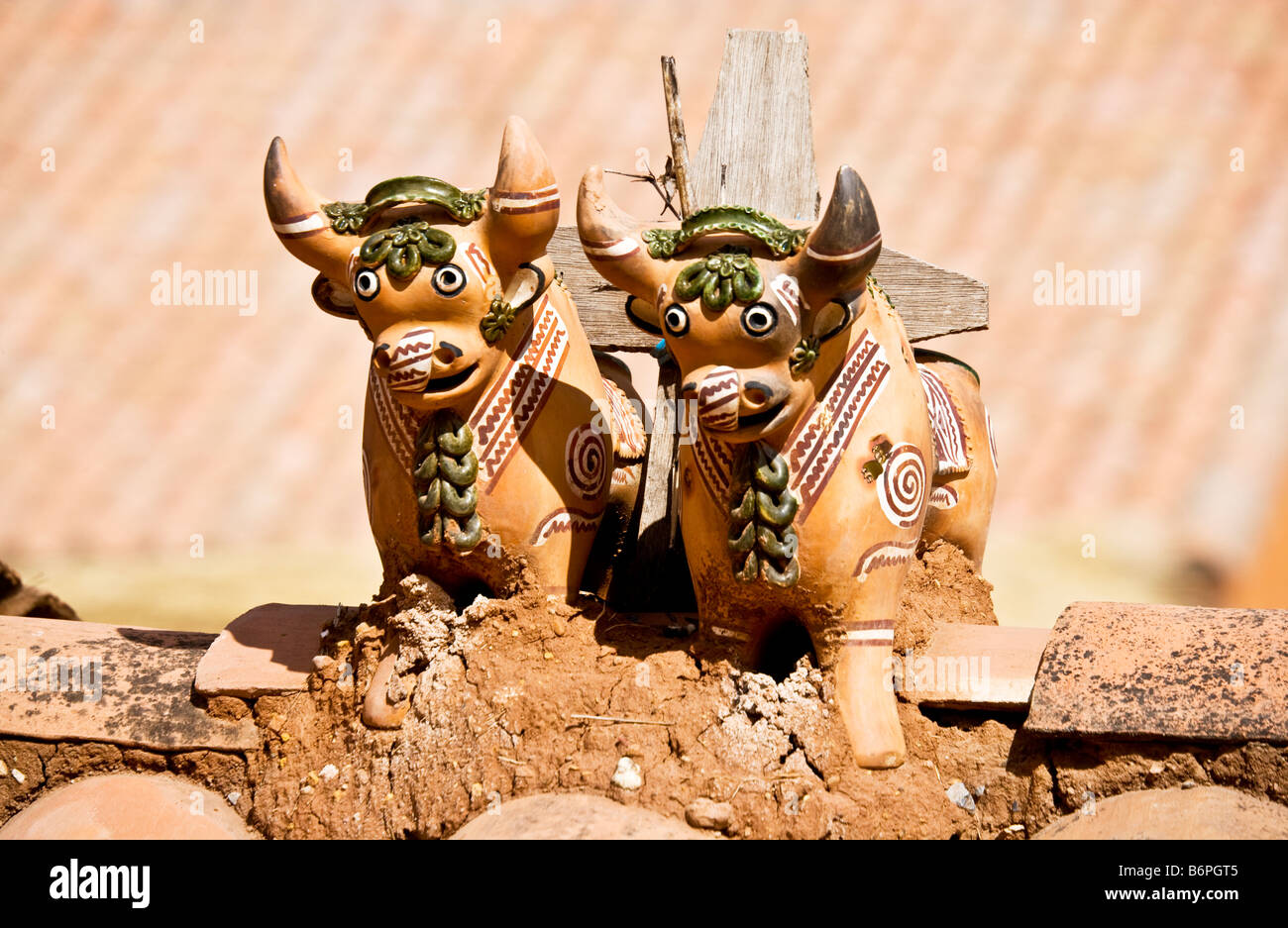 A pair of Toritos de Pucara or Little Bulls of Pucara and a wooden ...