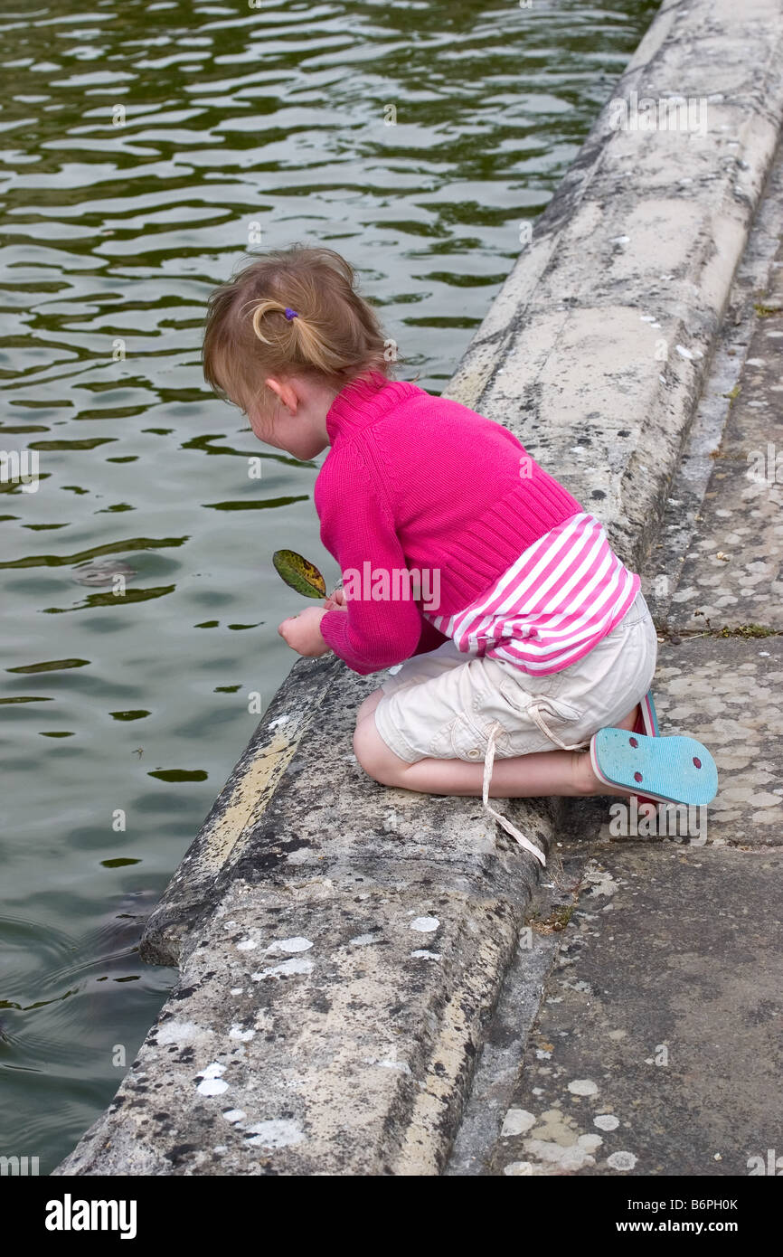 Little girl looking into water Stock Photo - Alamy