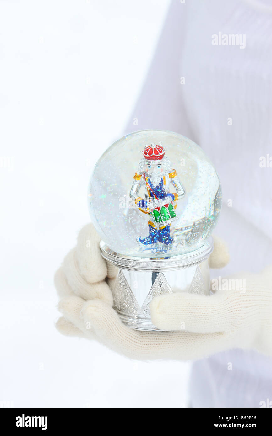Hands with winter gloves holding Christmas snow globe Stock Photo - Alamy