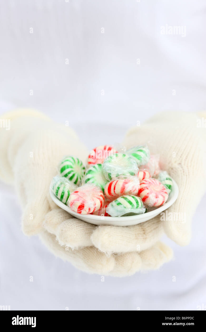 Hands with winter gloves holding Christmas mints Stock Photo - Alamy