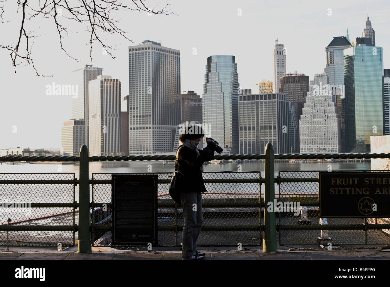 A man with a camera is seen in front of a view of downtown Manhattan in ...