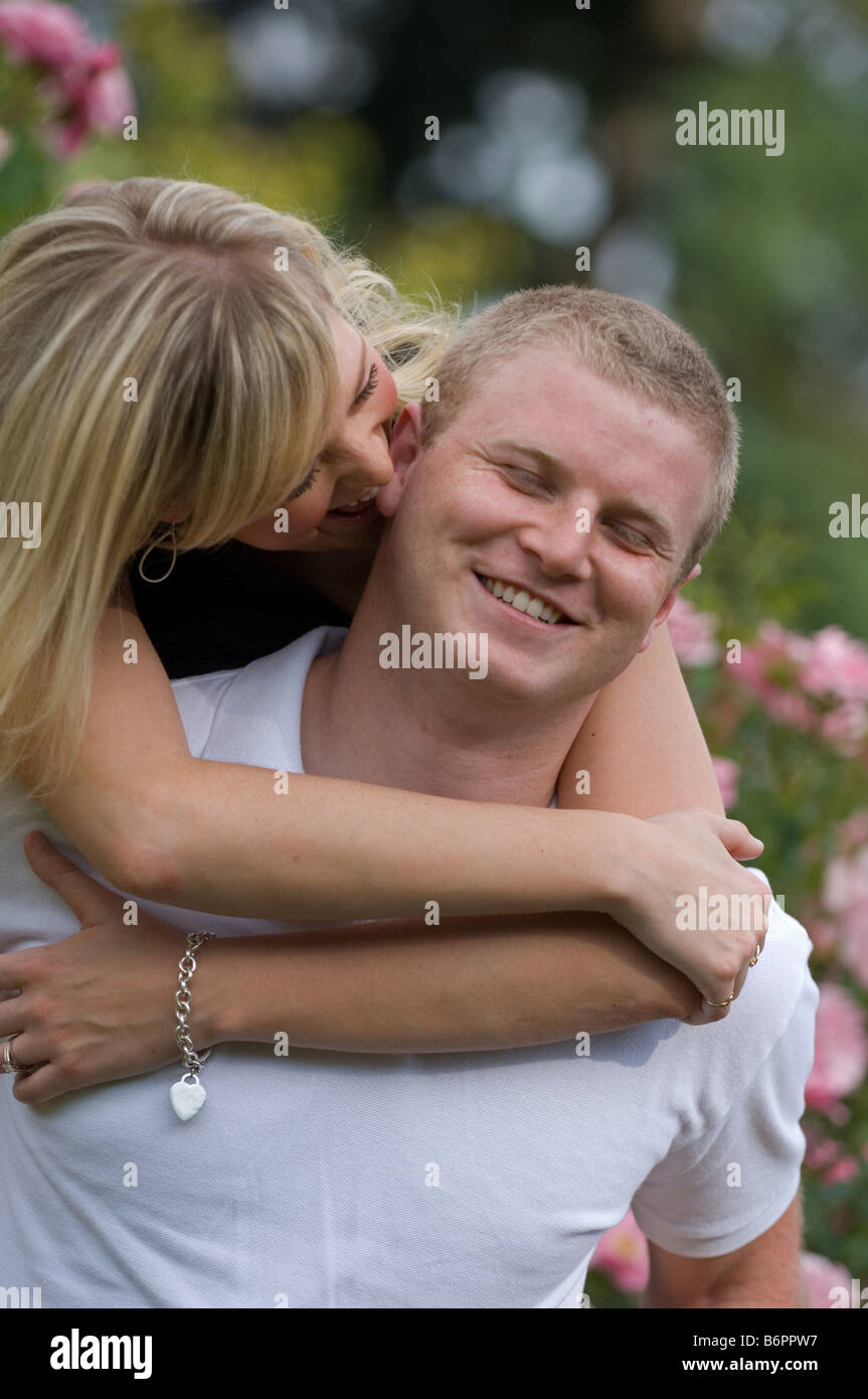 Woman biting the ear of her boyfriend Stock Photo - Alamy