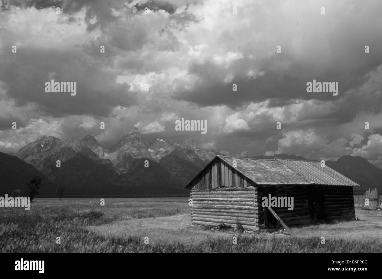 A restored 19th century log cabin with a view of the Teton Mountains in ...