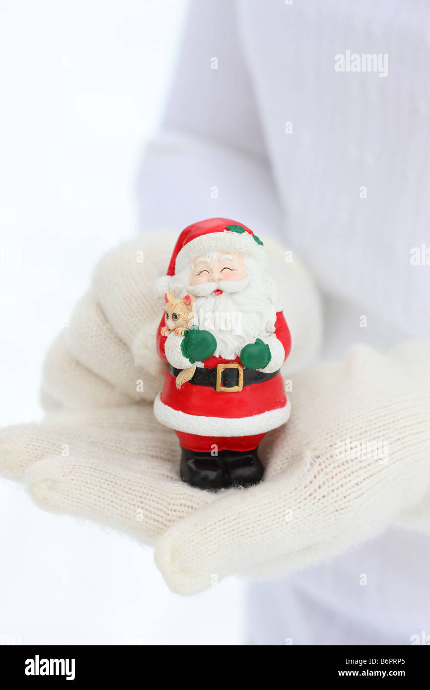 Hands with winter gloves holding Santa Claus Christmas figure Stock ...