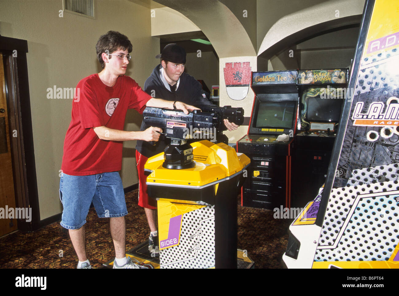 Teen boys plays arcade shooting game Stock Photo - Alamy