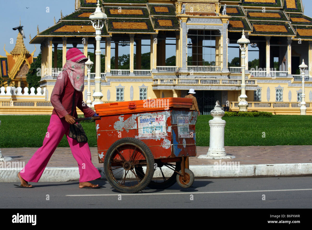 Woman selling ice cream in a trolley completely covered with clothes ...