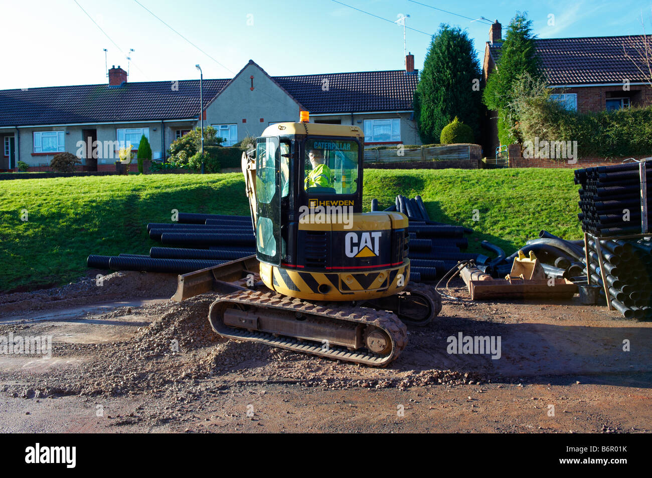 Road digger tractor working on road after laying electrical cabling ...