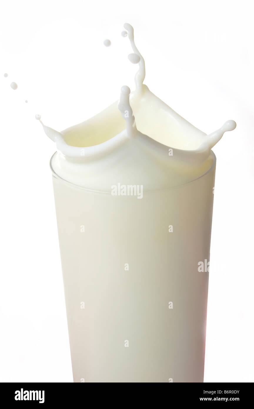 Milk being splashed out from a glass on white background Stock Photo ...