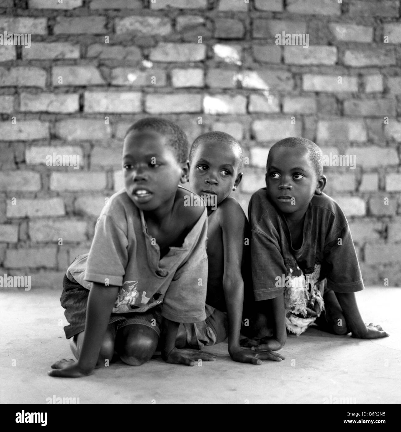 Three kids on concrete floor Stock Photo - Alamy