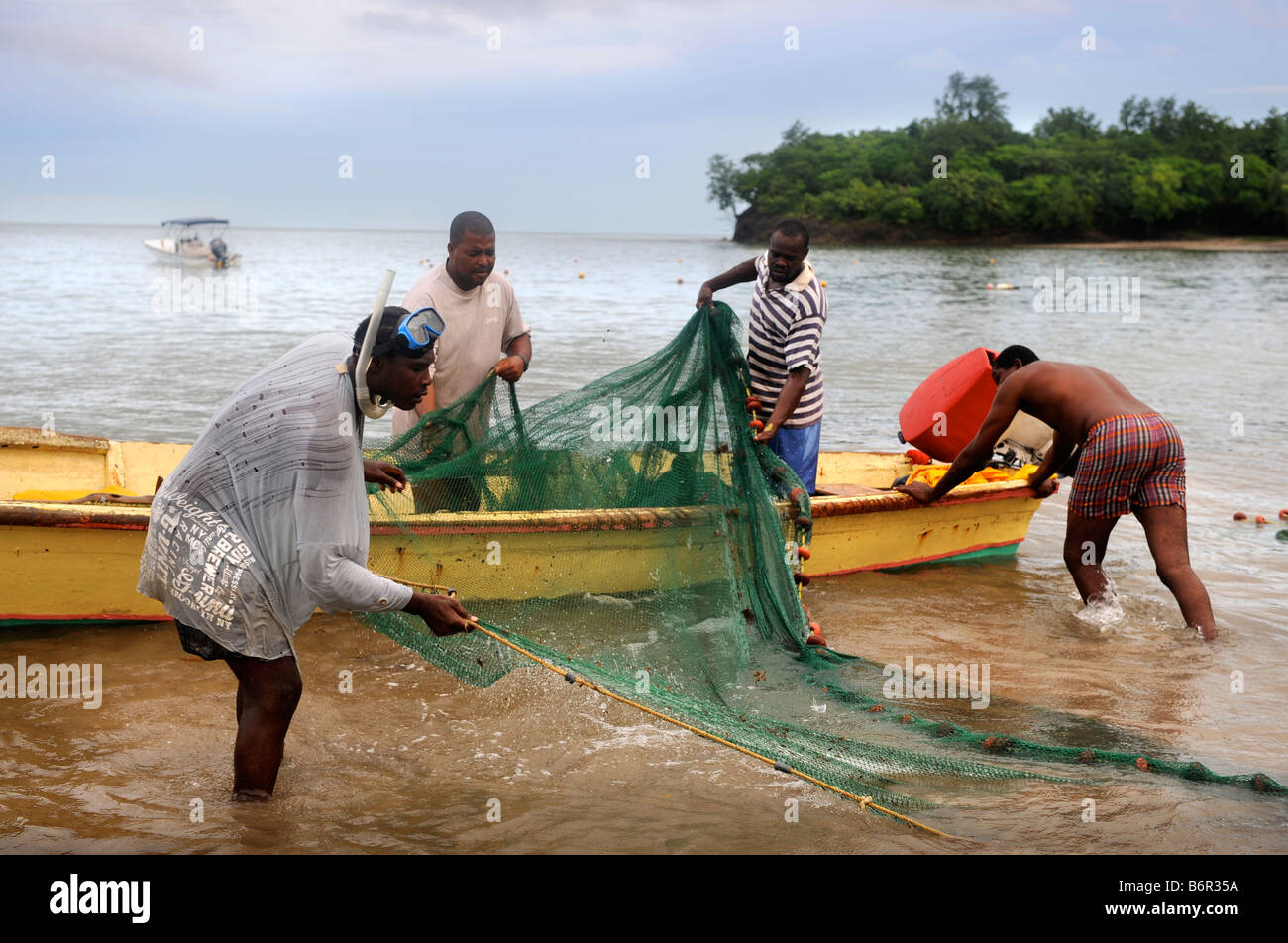 ARTISAN FISHERMEN CLEAN THEIR NETS OFF THE BEACH AT THE MORGAN BAY ...