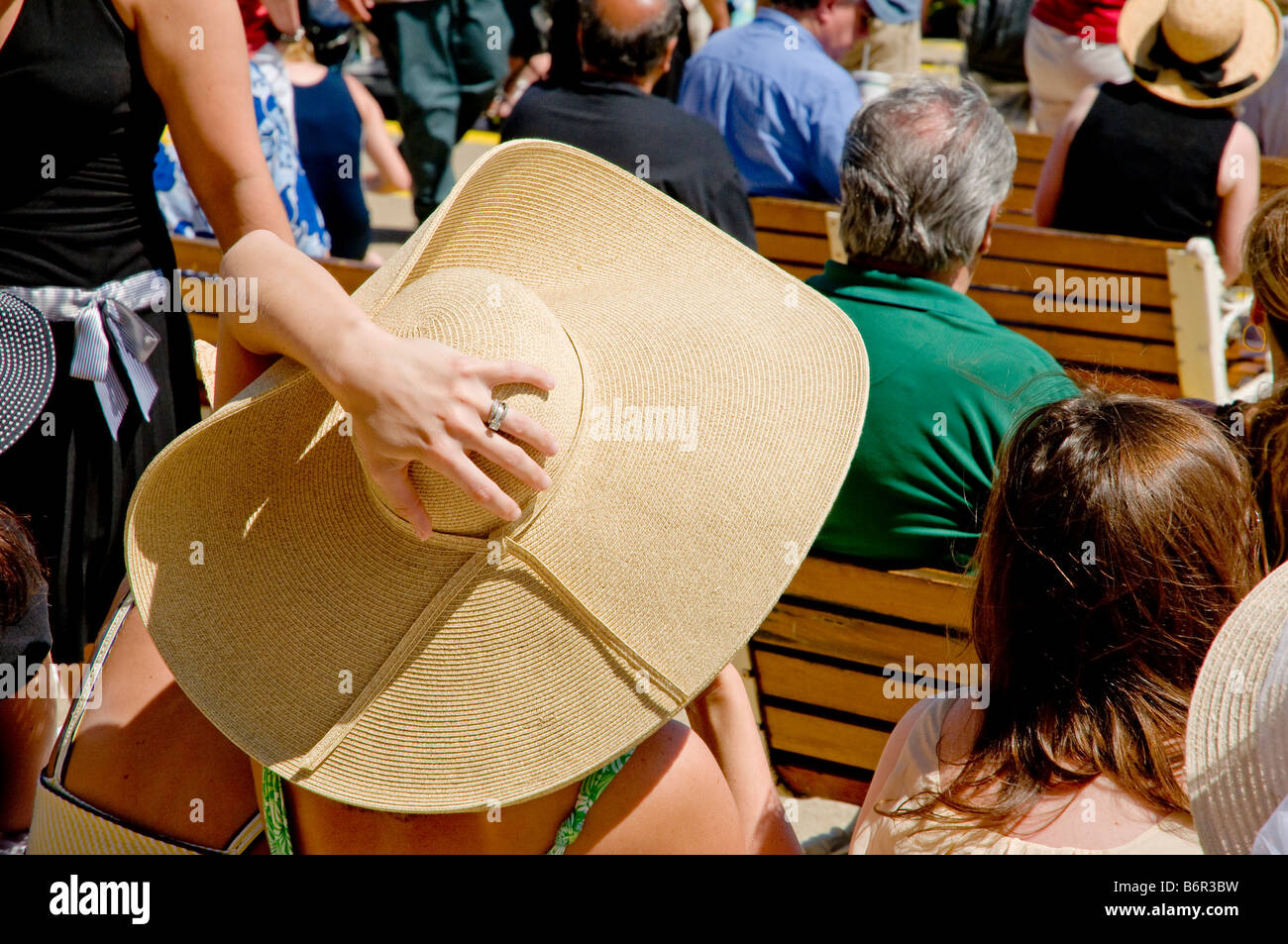 Female horse racing fans wearing hats watching the start of a turf race ...