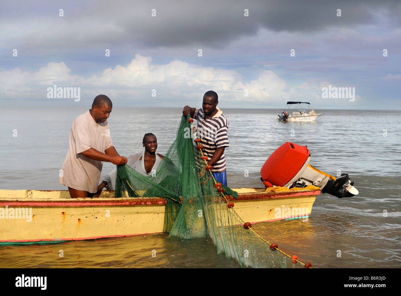 ARTISAN FISHERMEN CLEAN THEIR NETS OFF THE BEACH AT THE MORGAN BAY ...