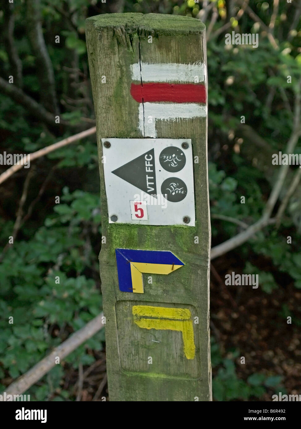 sign for different hiking routes on a post with symbol for grand ...