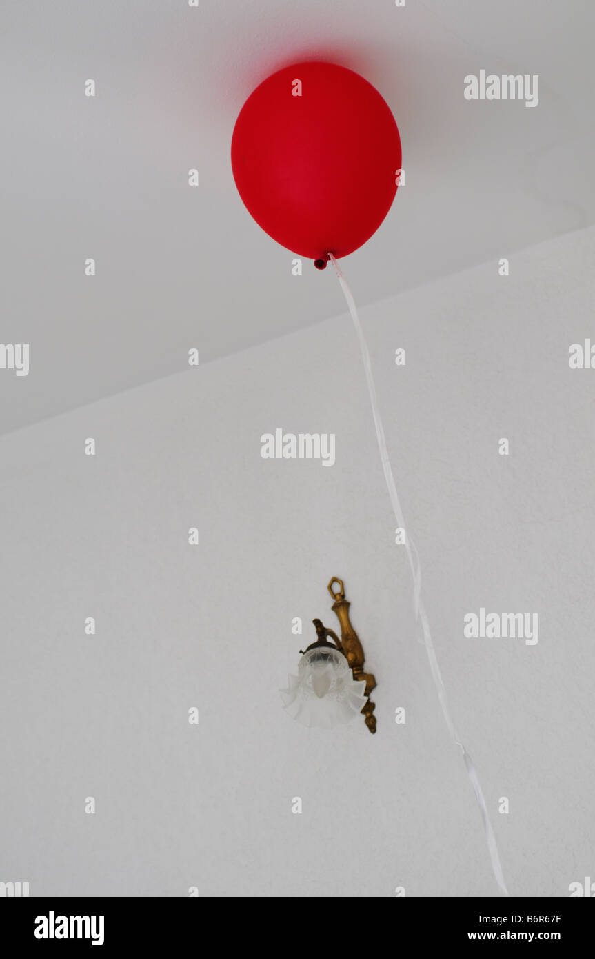 Red balloon on the ceiling in a room Stock Photo - Alamy