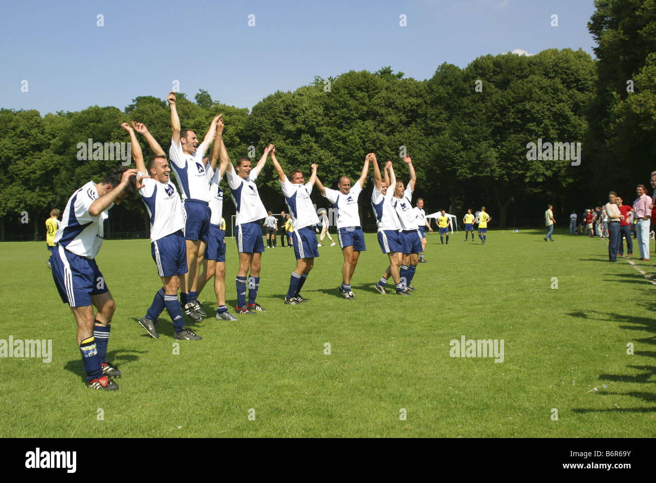 football team with their arms outstretched into the air Stock Photo - Alamy