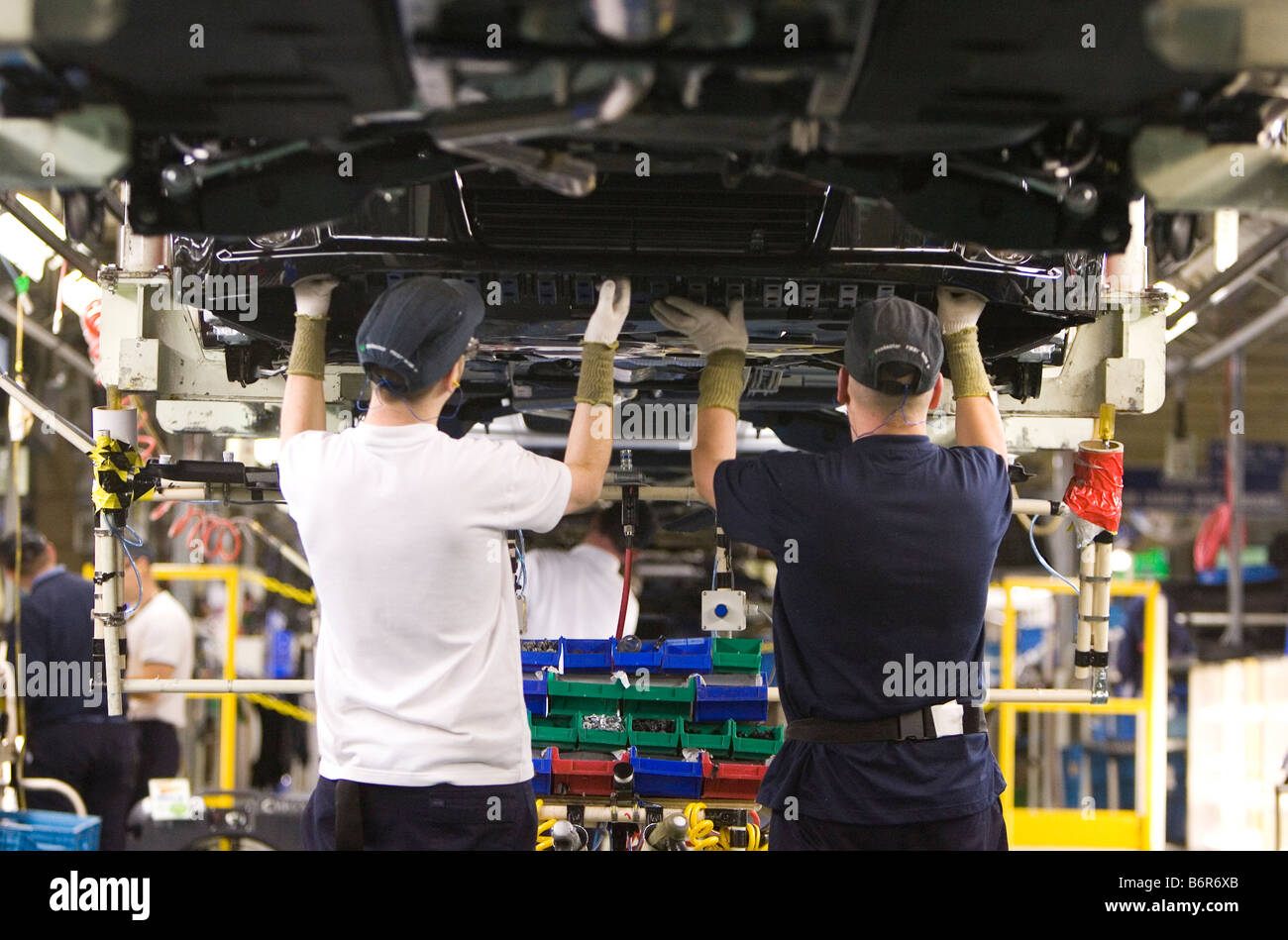 Workers at Toyota Final Assembly production line fit parts to the ...