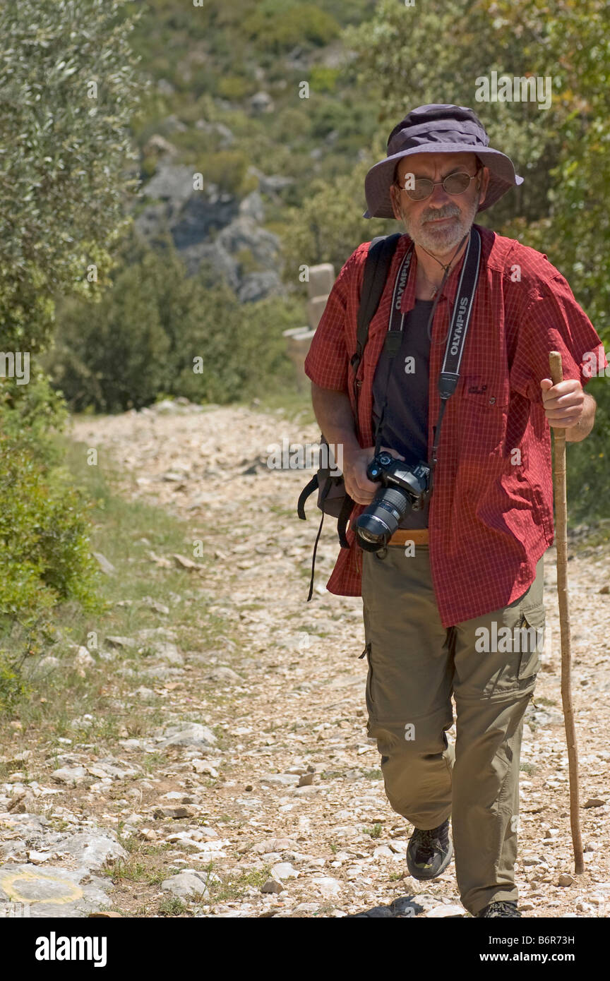 middle aged man with a camera hiking in mediterranean landscape on ...