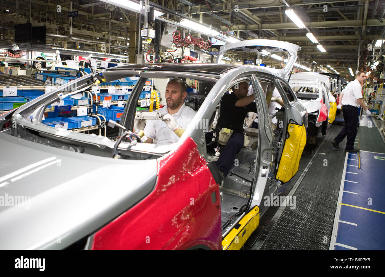 Workers at Toyota Final Assembly production line fit parts to the ...