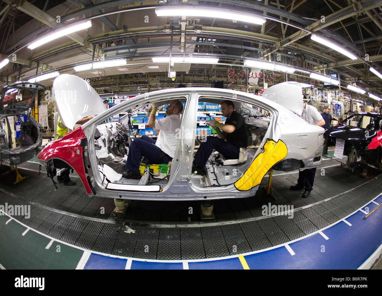 Workers at Toyota Final Assembly production line fit parts to the ...