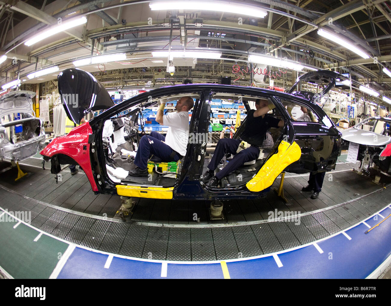 Workers at Toyota Final Assembly production line fit parts to the ...