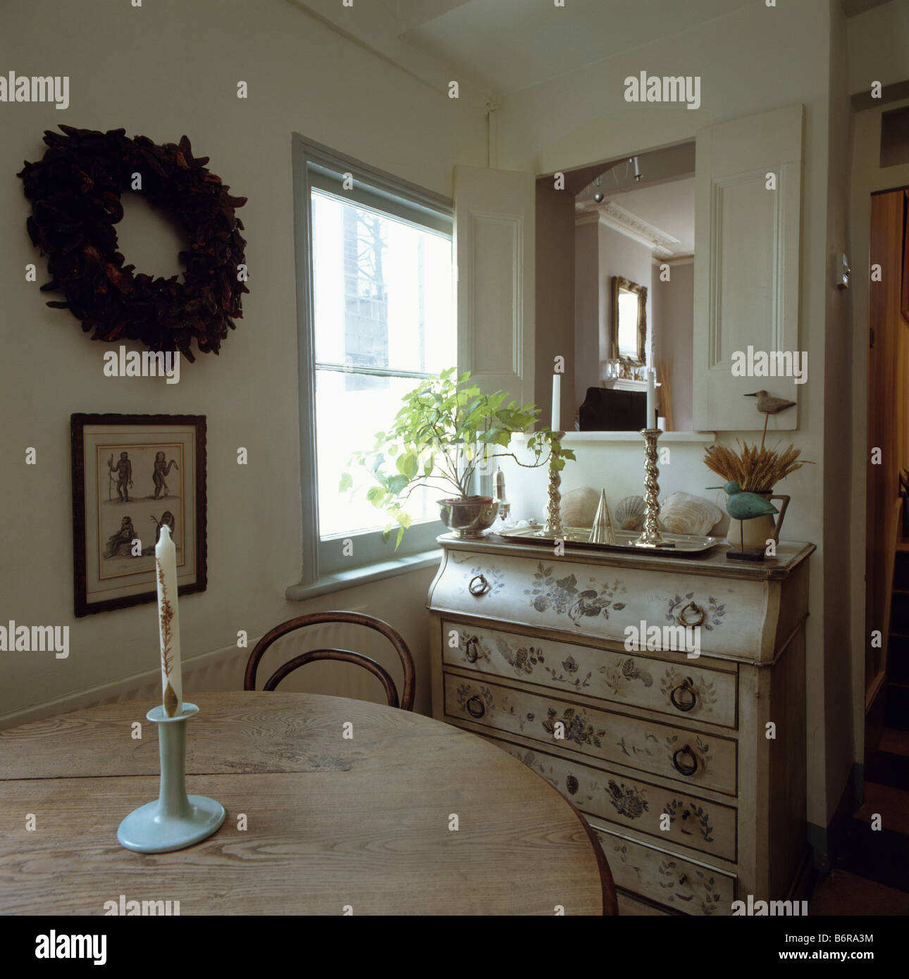 Wooden shutters on hatch above painted antique bureau in dining room ...