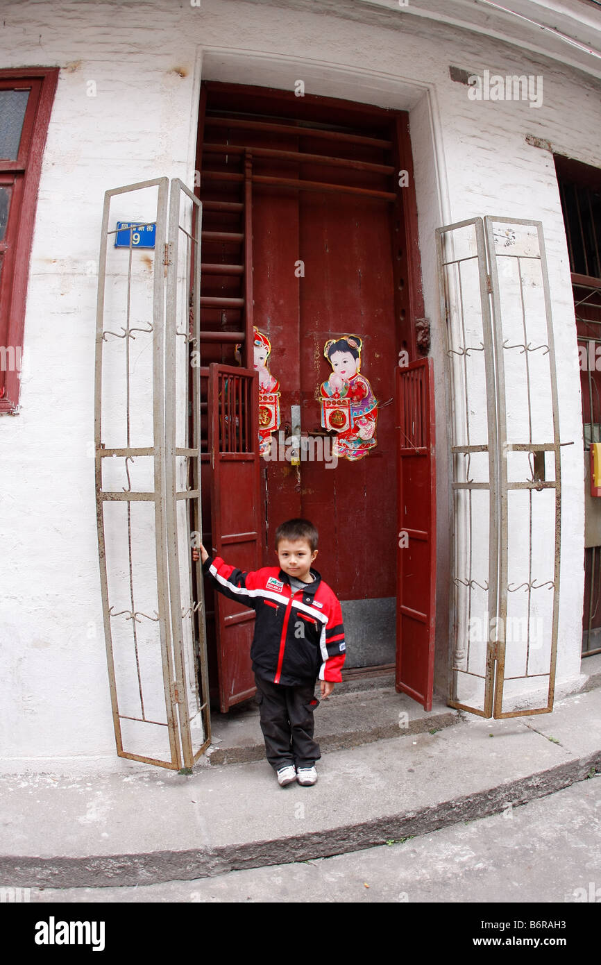 Asian boy waiting in front of house in Guangzhou Guangdong Canton China ...