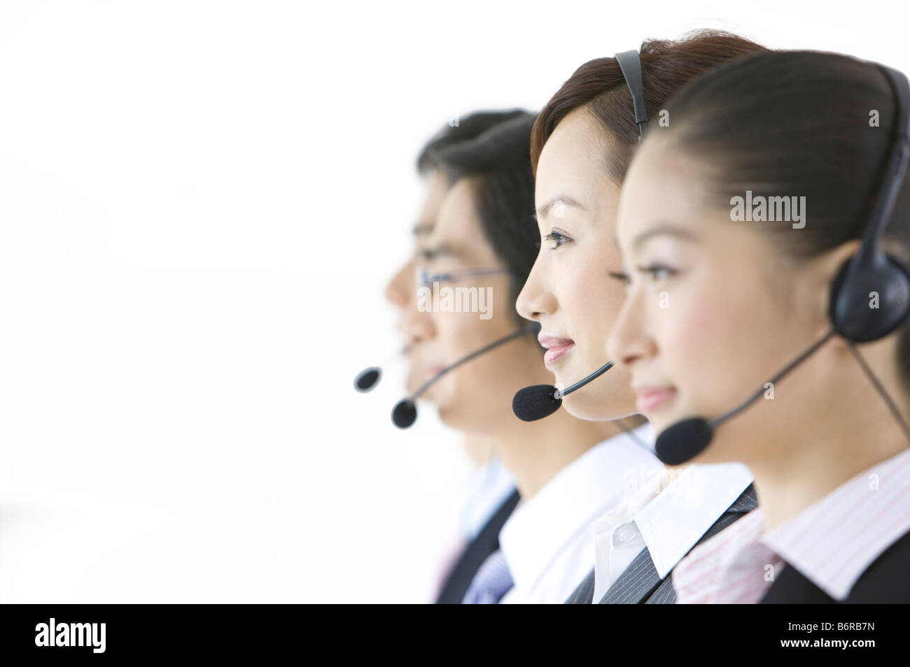 Business people wearing the headphone in a row side view Stock Photo ...