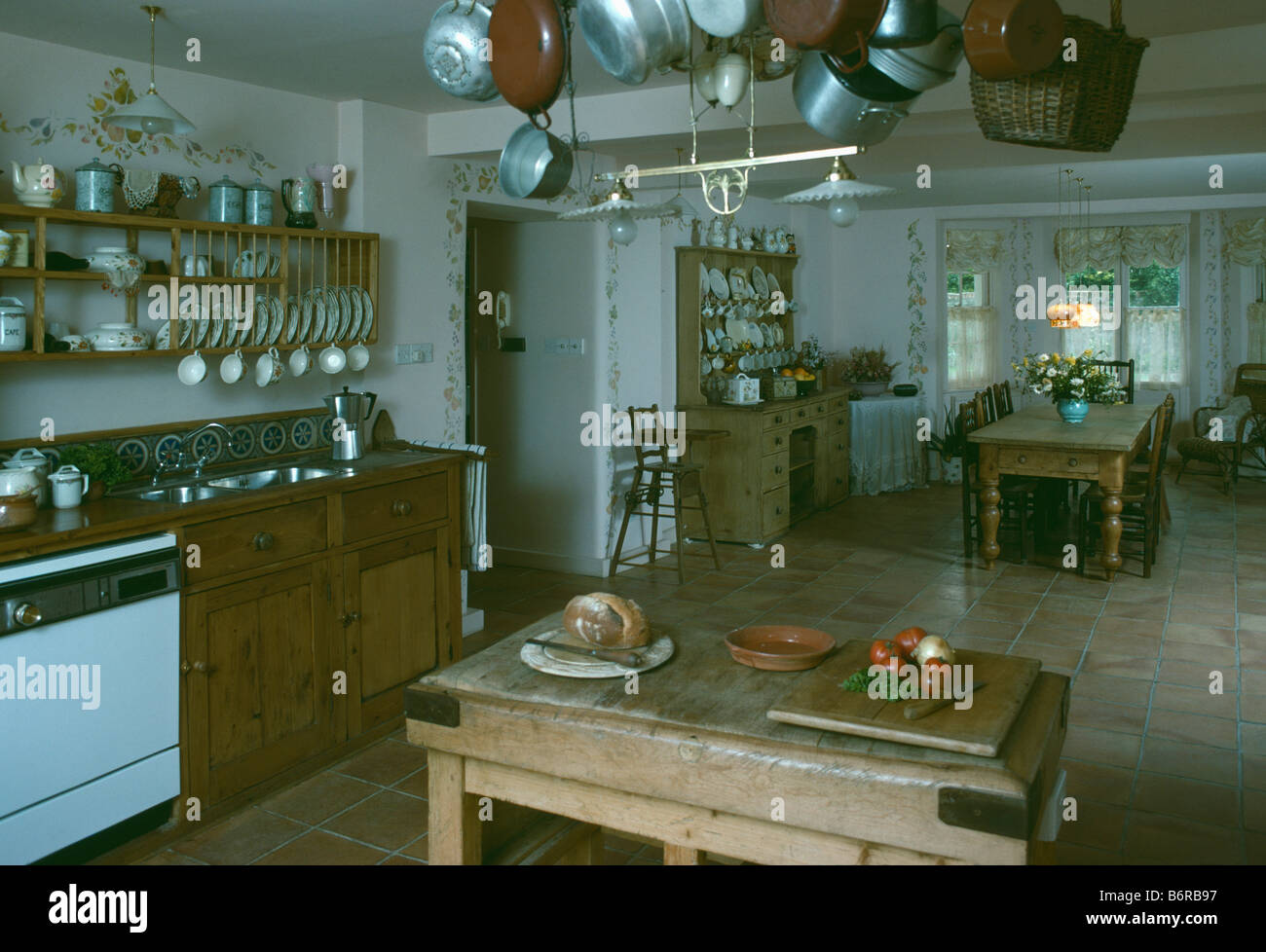 Pans on storage rack above old butcher's block in dark basement kitchen ...