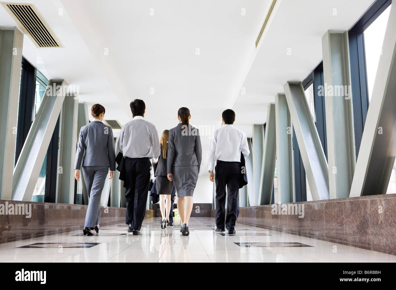 Business people walking in the office building rear view Stock Photo ...