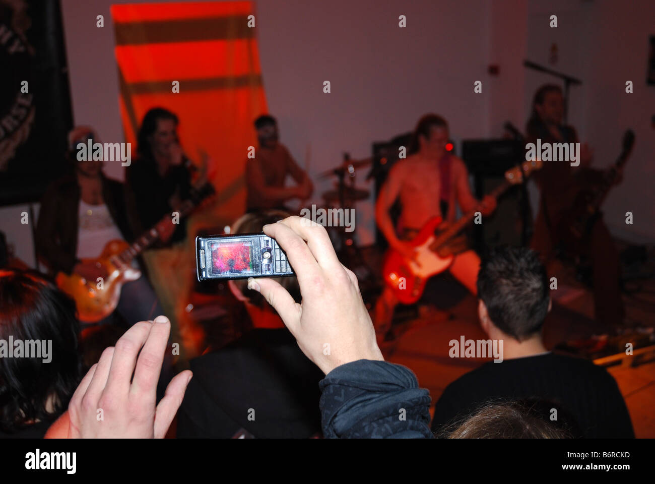 spectator taking snapshot at rock concert with digital phone camera ...