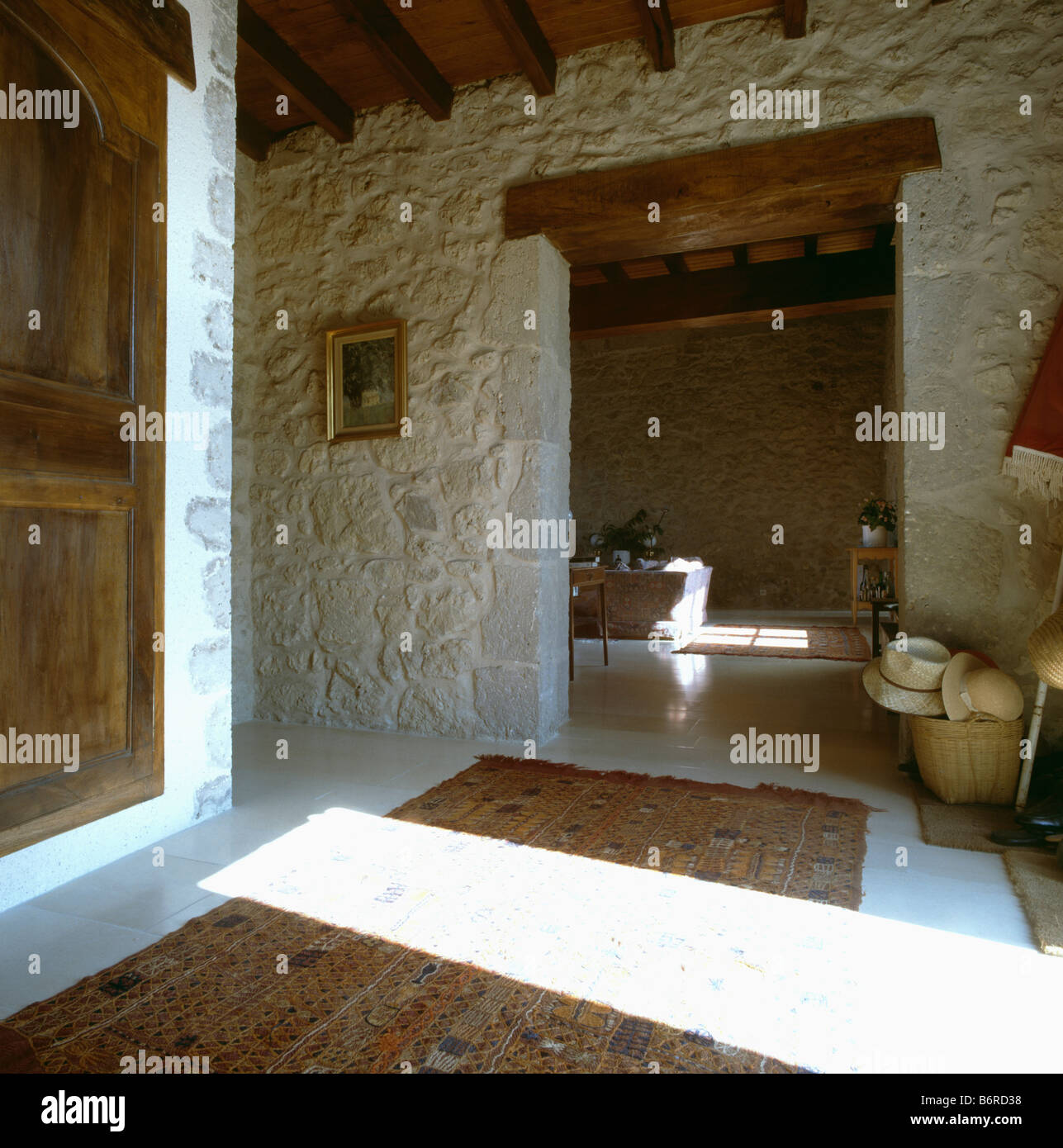 Stone walls and shaft of sunlight on floor of rustic French country ...