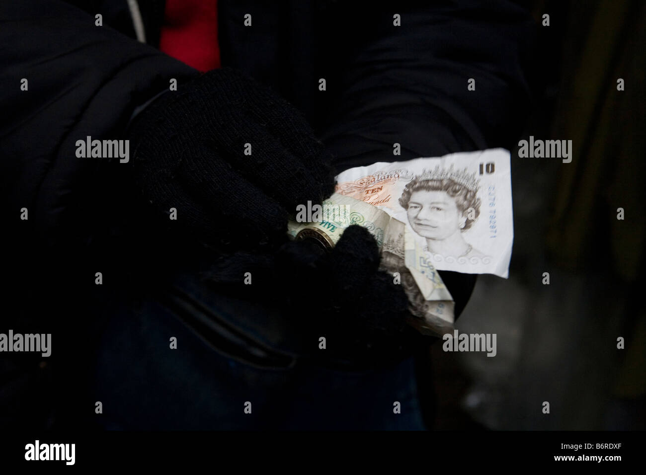 A market stall holder showing money 10 5 notes and coins on at a market ...