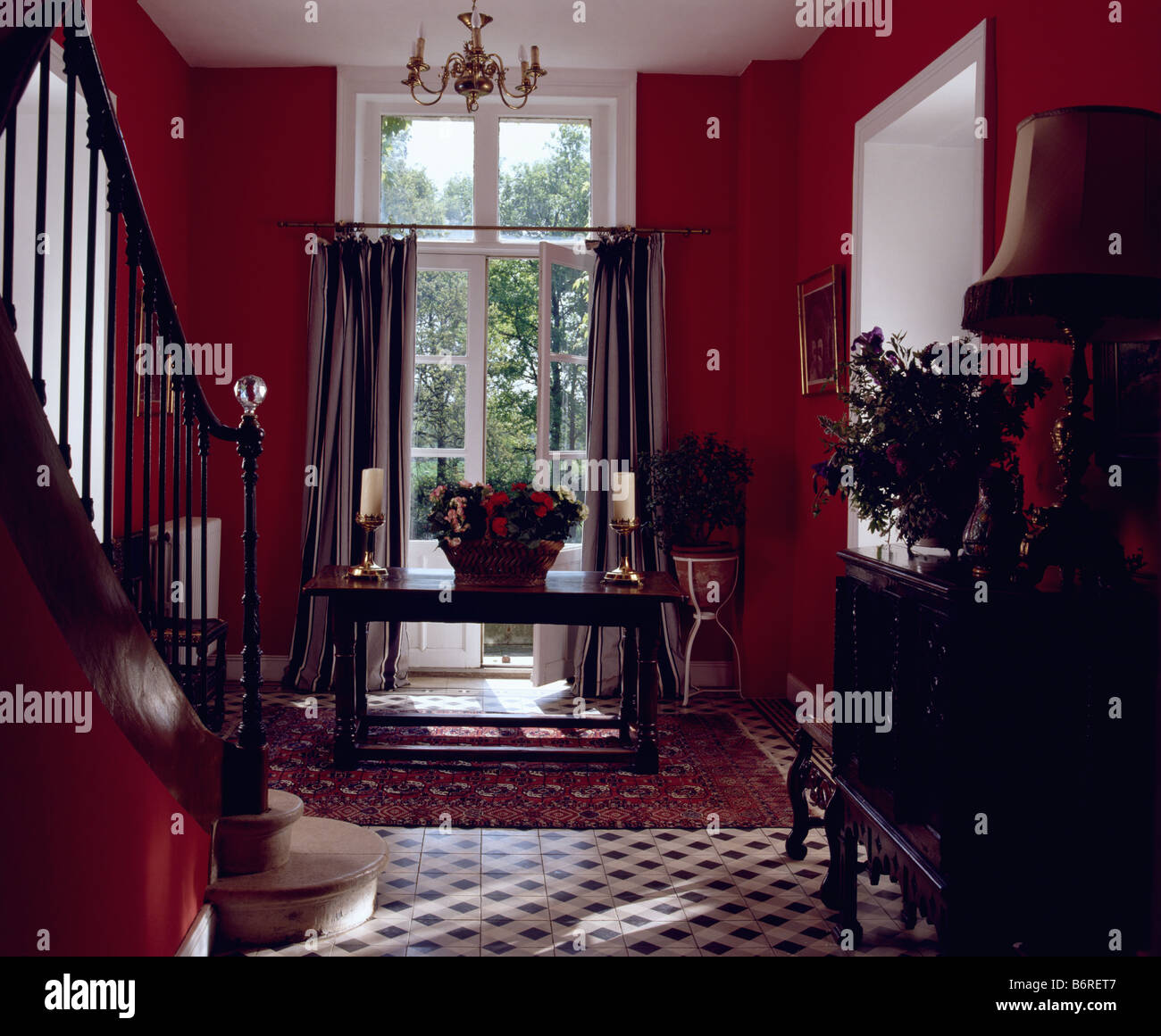 Ceramic floor tiles and antique console table in red country hall Stock ...