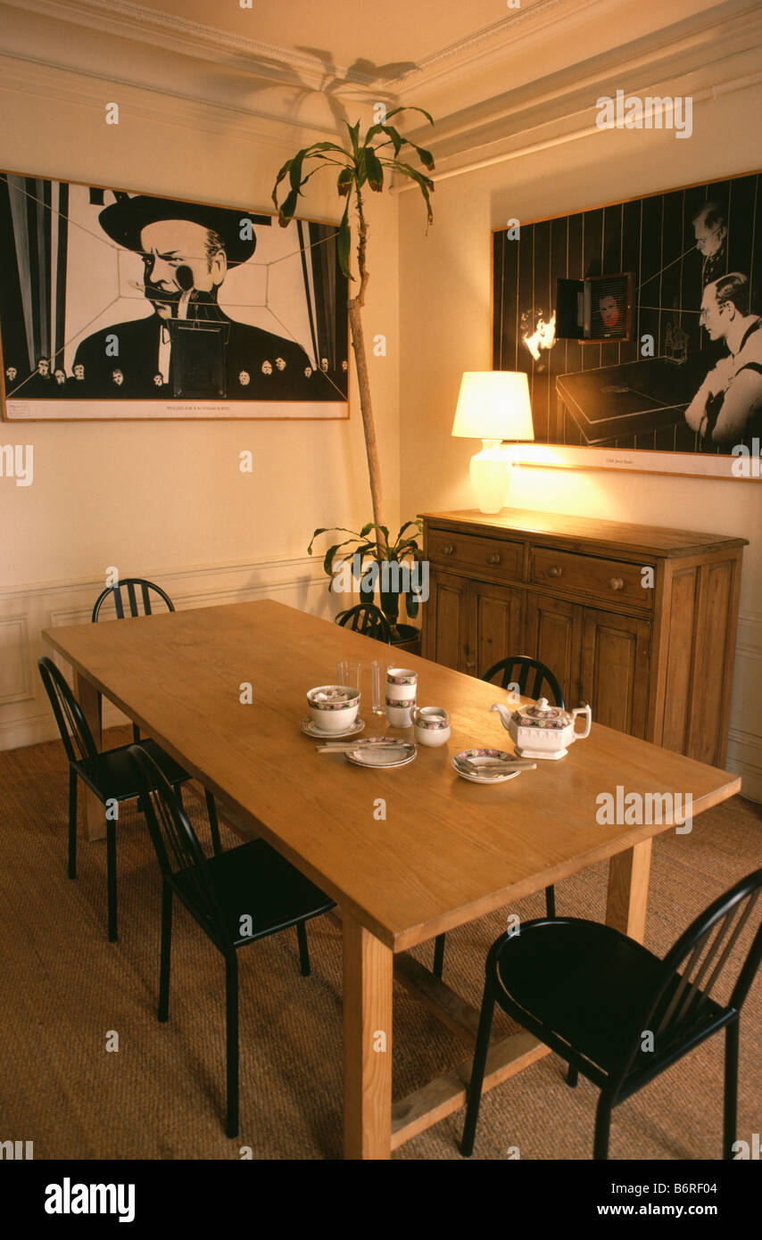 Teapot and china teaset on wooden table in dining room with pictures on ...
