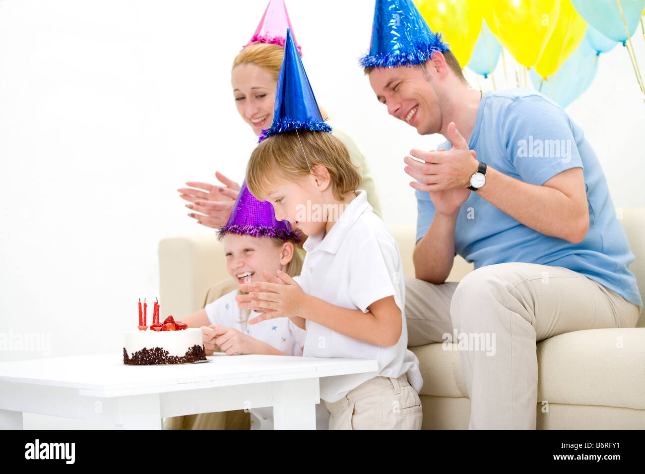 Parents with two children celebrating birthday smiling side view Stock ...