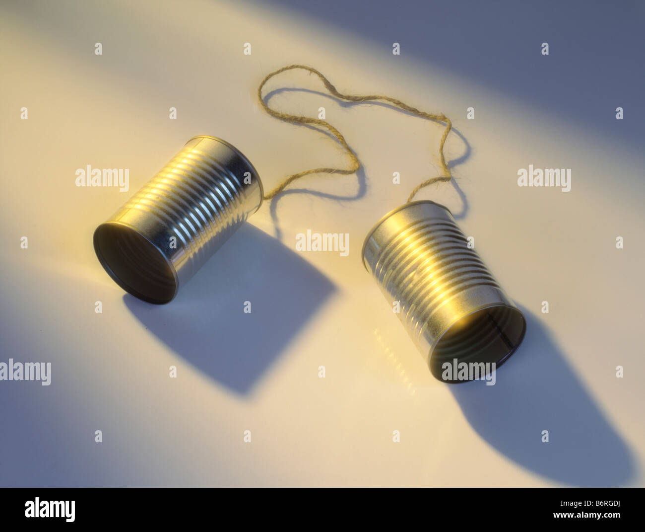 two tin cans with twine attached between in warm lighting and softened ...