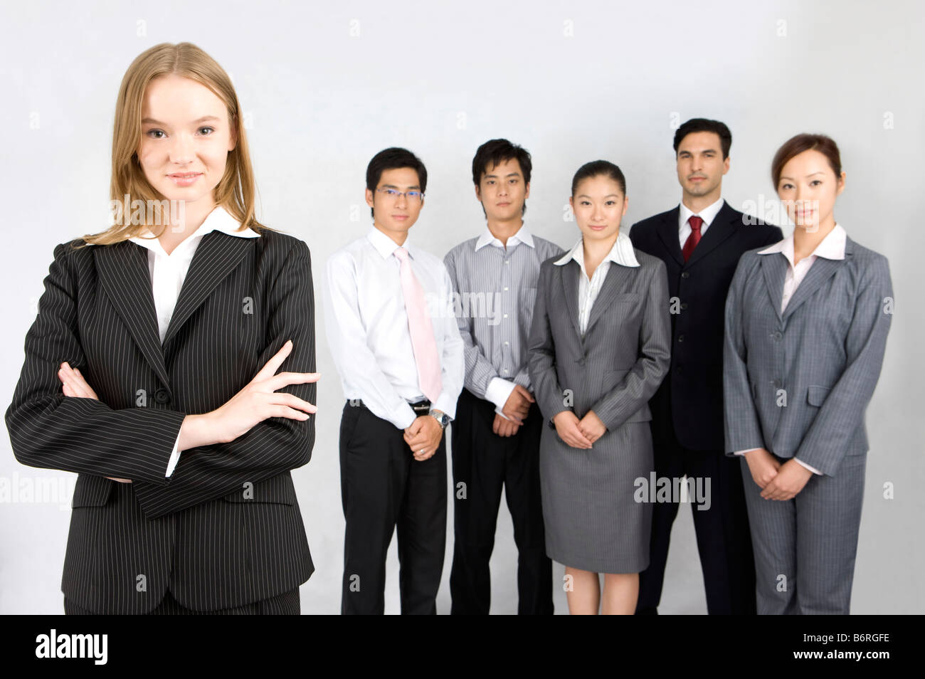 Business people looking at the camera and standing in a row with one ...