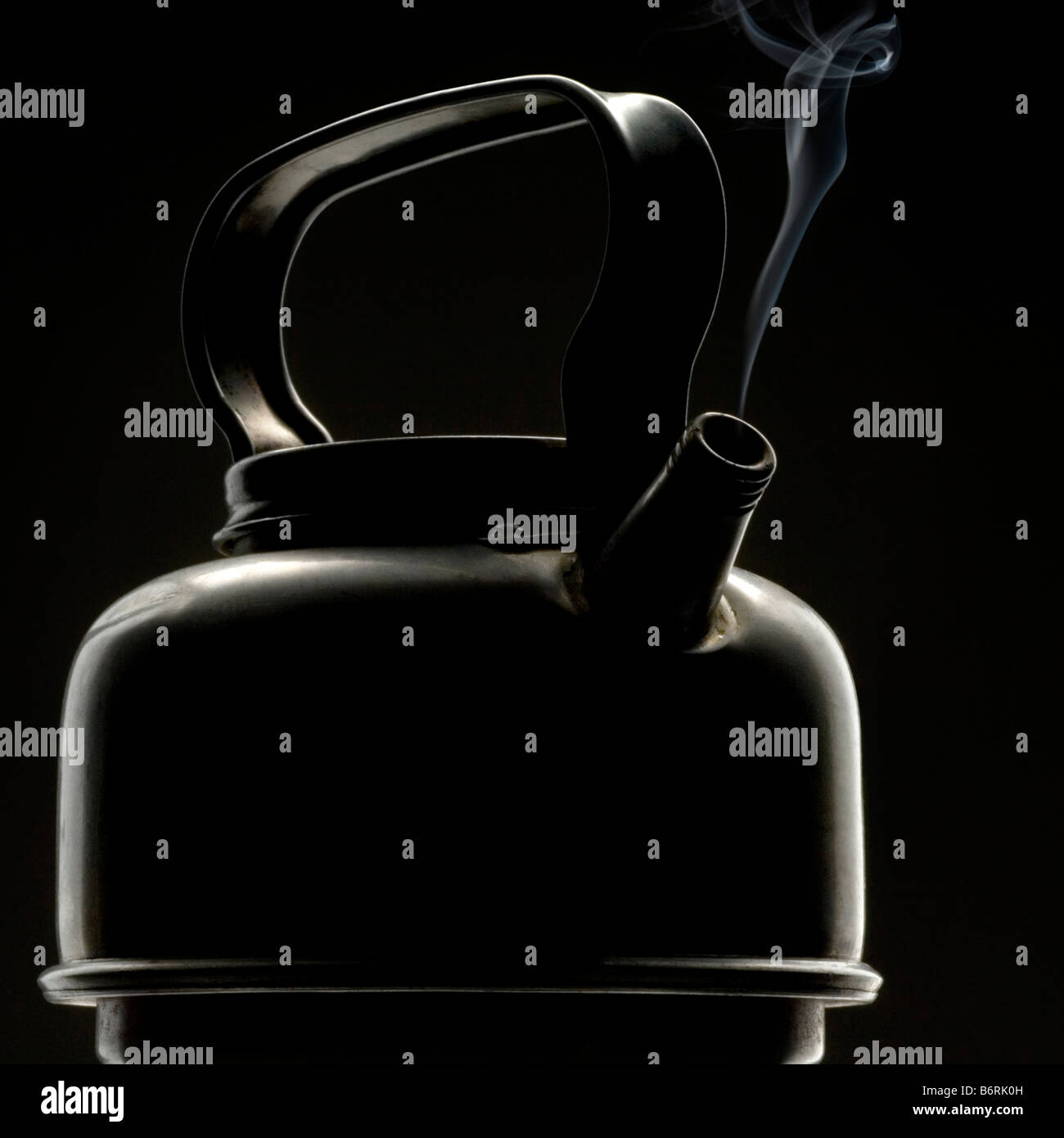 a fuming metal teapot against dark background silhouette Stock Photo ...