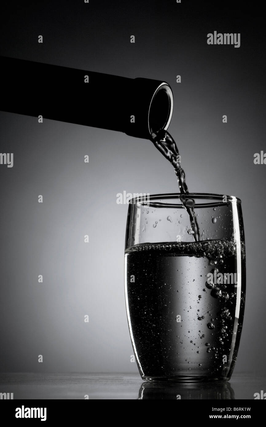 water being poured from the bottle to the glass backlit Stock Photo - Alamy