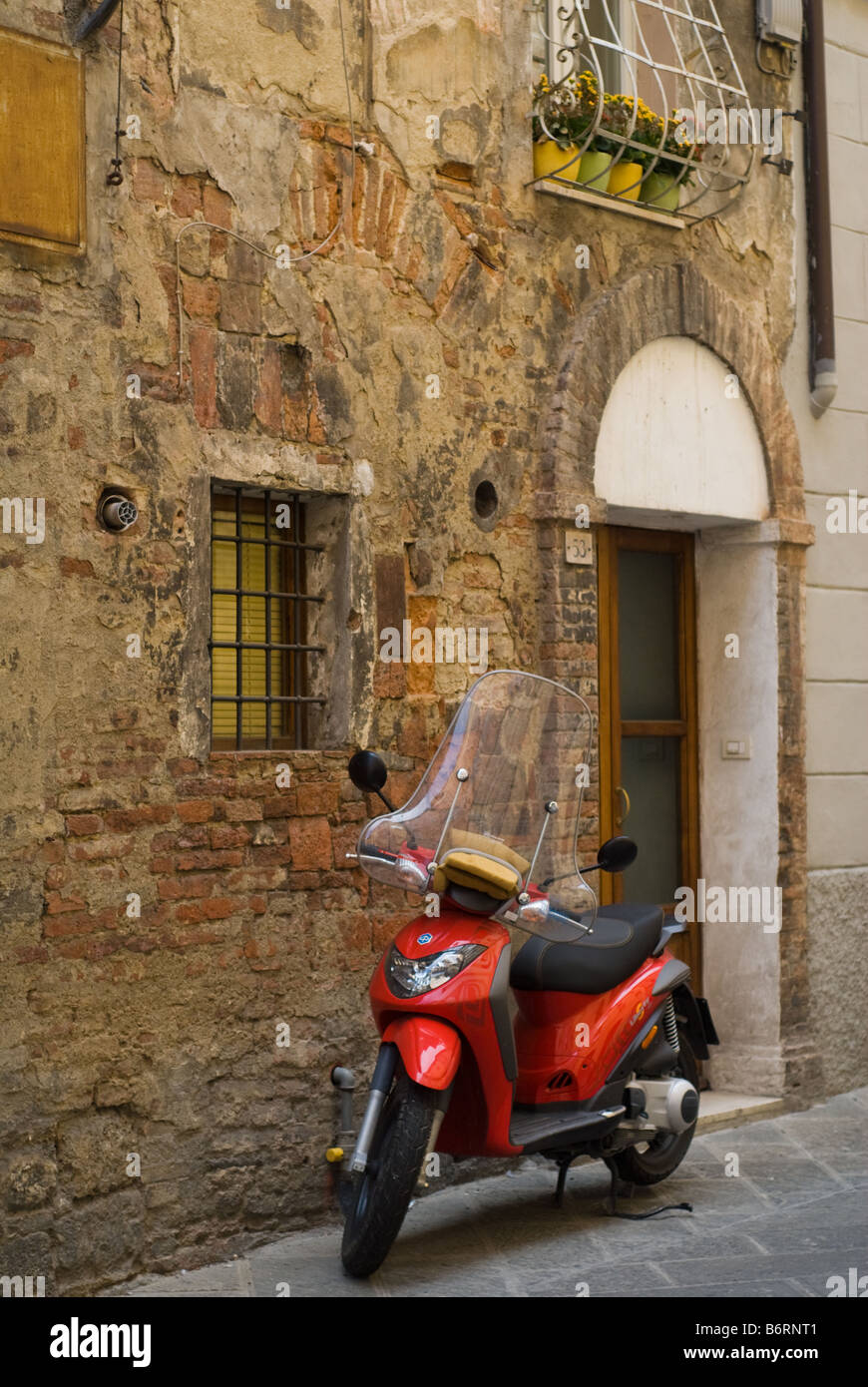 Red Scooter parked outside a typical home in Siena, Tuscany, Italy ...