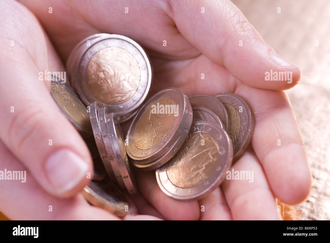 Child's hands holding coins Stock Photo - Alamy