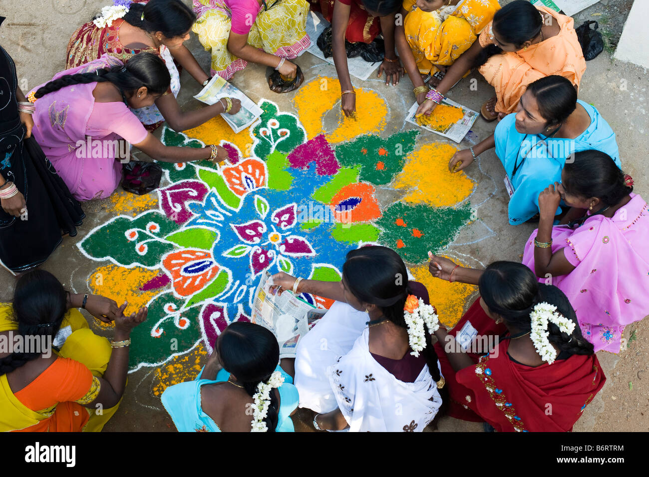 Indian teenage girls making a rangoli sankranthi festival design on a ...