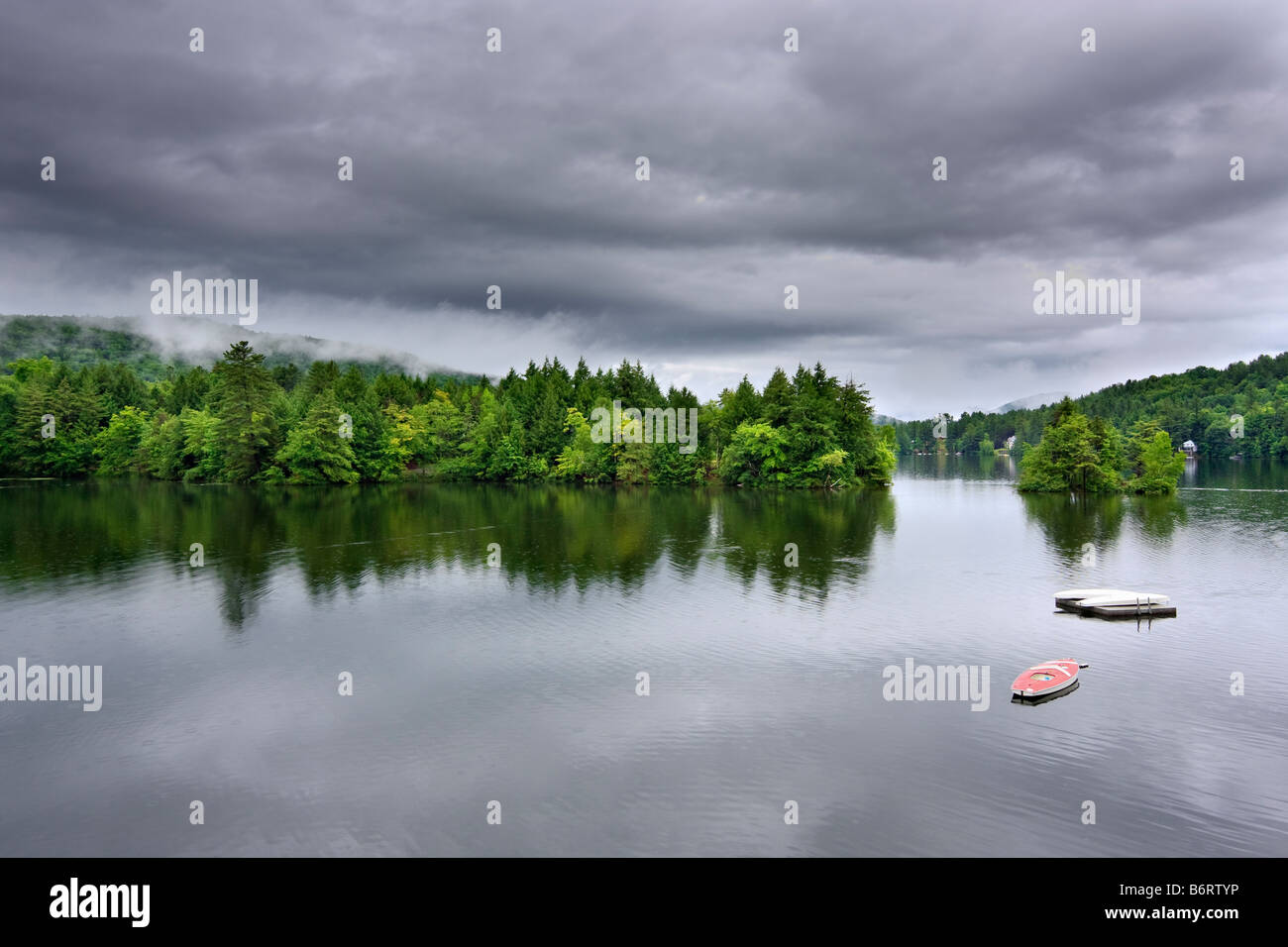 A lake during a rain storm. There are dark ominous rain clouds overhead ...