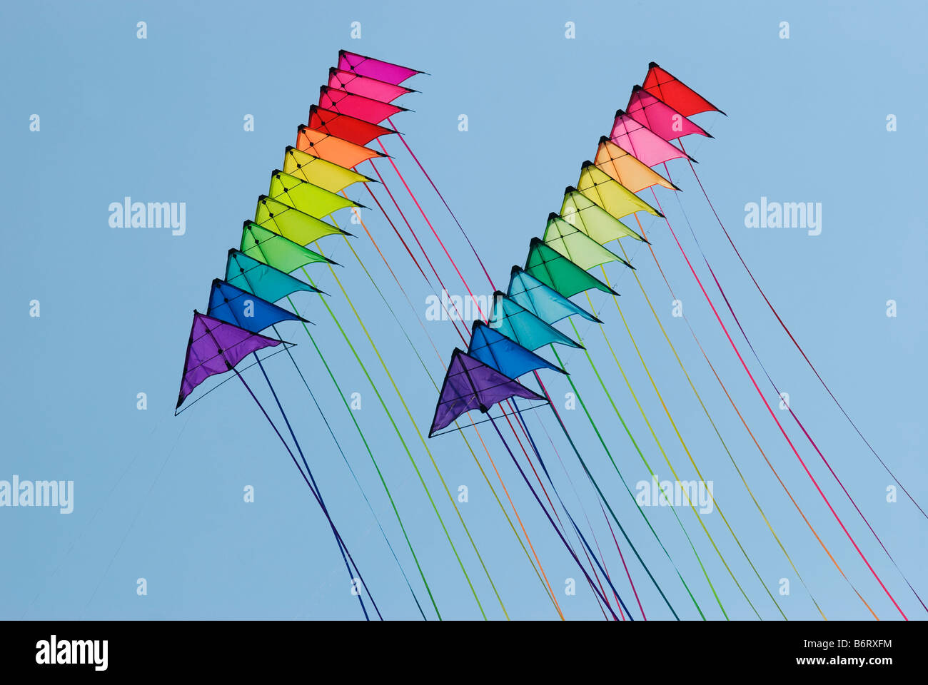 Two stacks of 12 stunt kites in rainbow colours on a blue sky ...