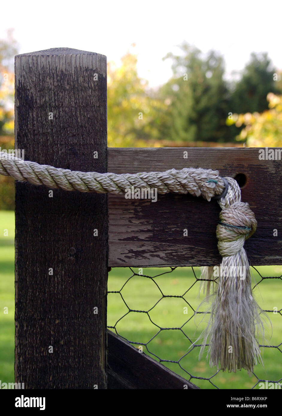Gates held closed with loosely tied rope Stock Photo - Alamy